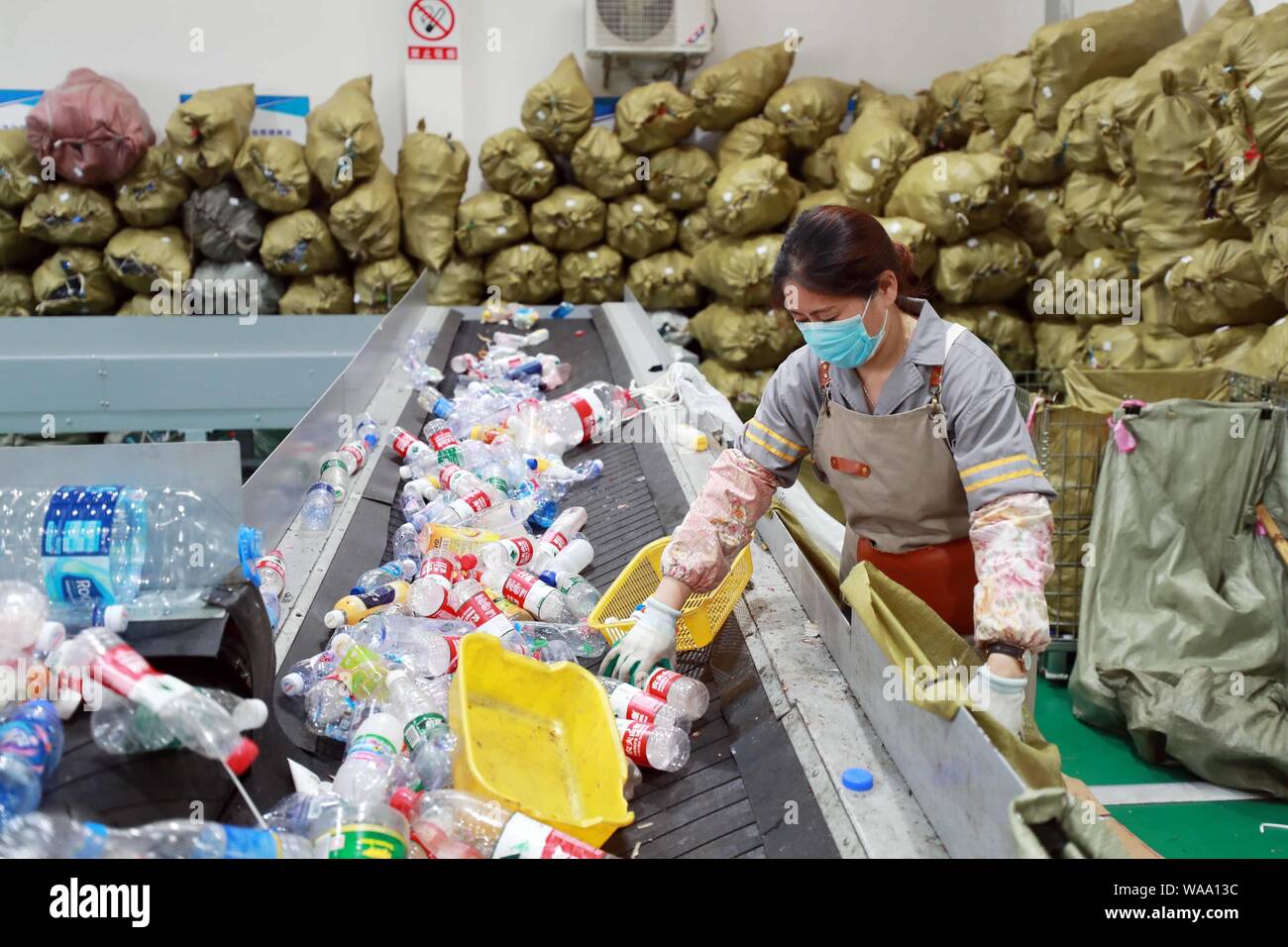 A Chinese worker sorts out recycling waste at a distribution center of ...