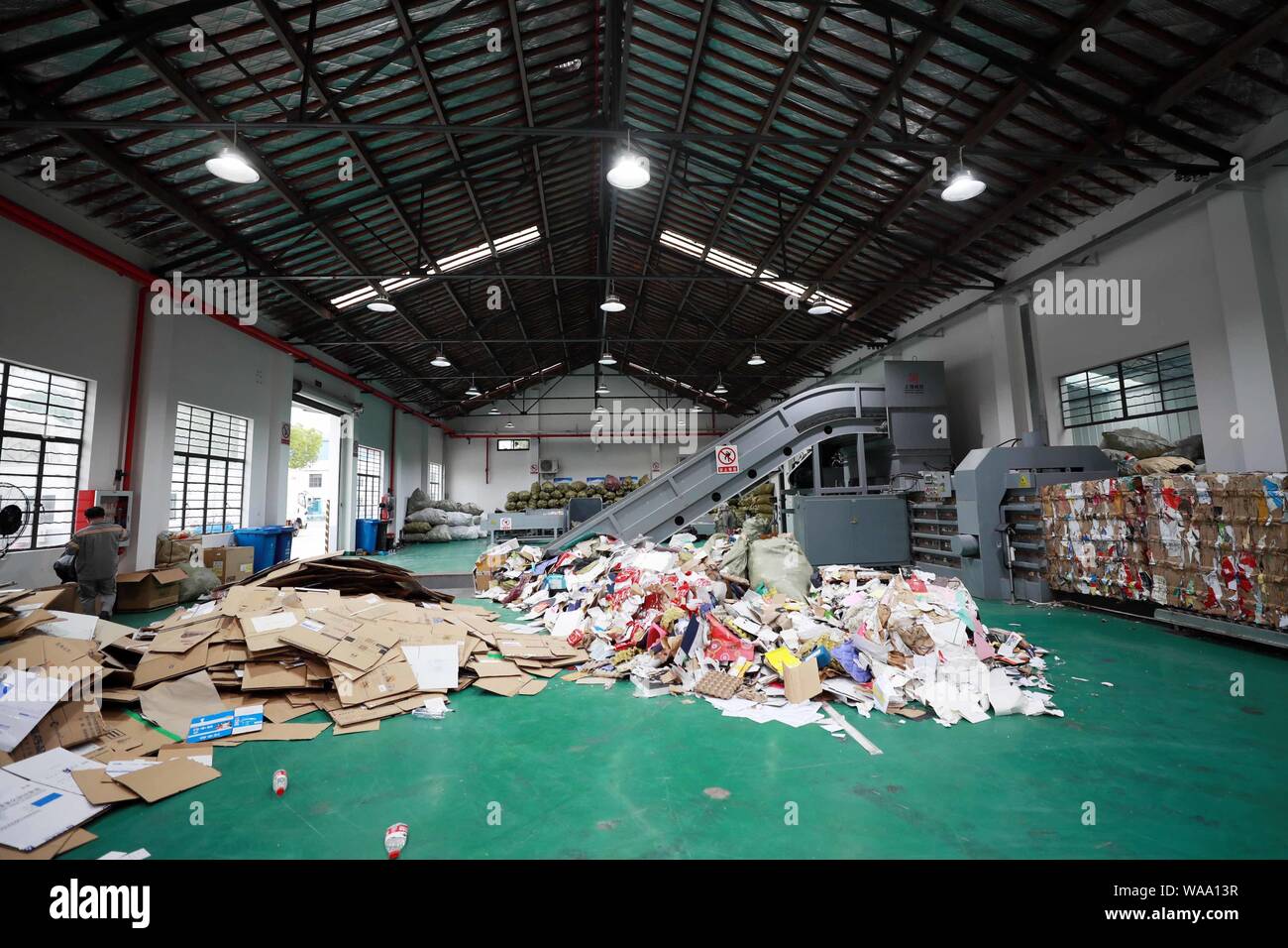 A Chinese worker sorts out recycling waste at a distribution center of ...