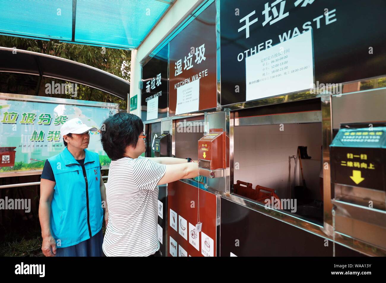 A local resident throws rubbish into different bins deployed to meet ...