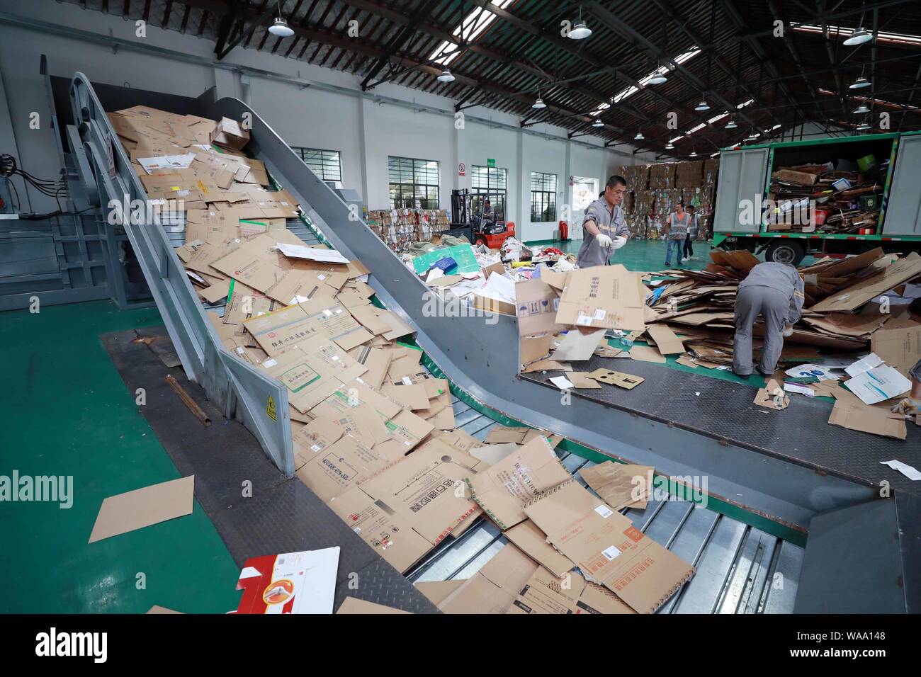 A Chinese worker sorts out recycling waste at a distribution center of ...