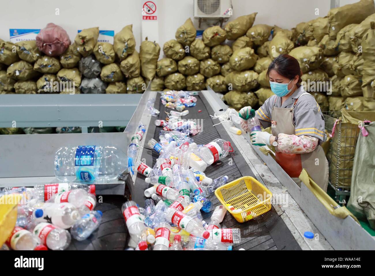 A Chinese worker sorts out recycling waste at a distribution center of ...