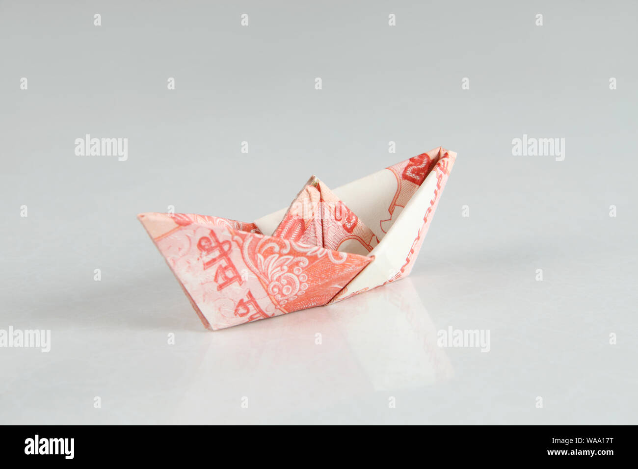 Paper boat of twenty rupee note on white background Stock Photo - Alamy