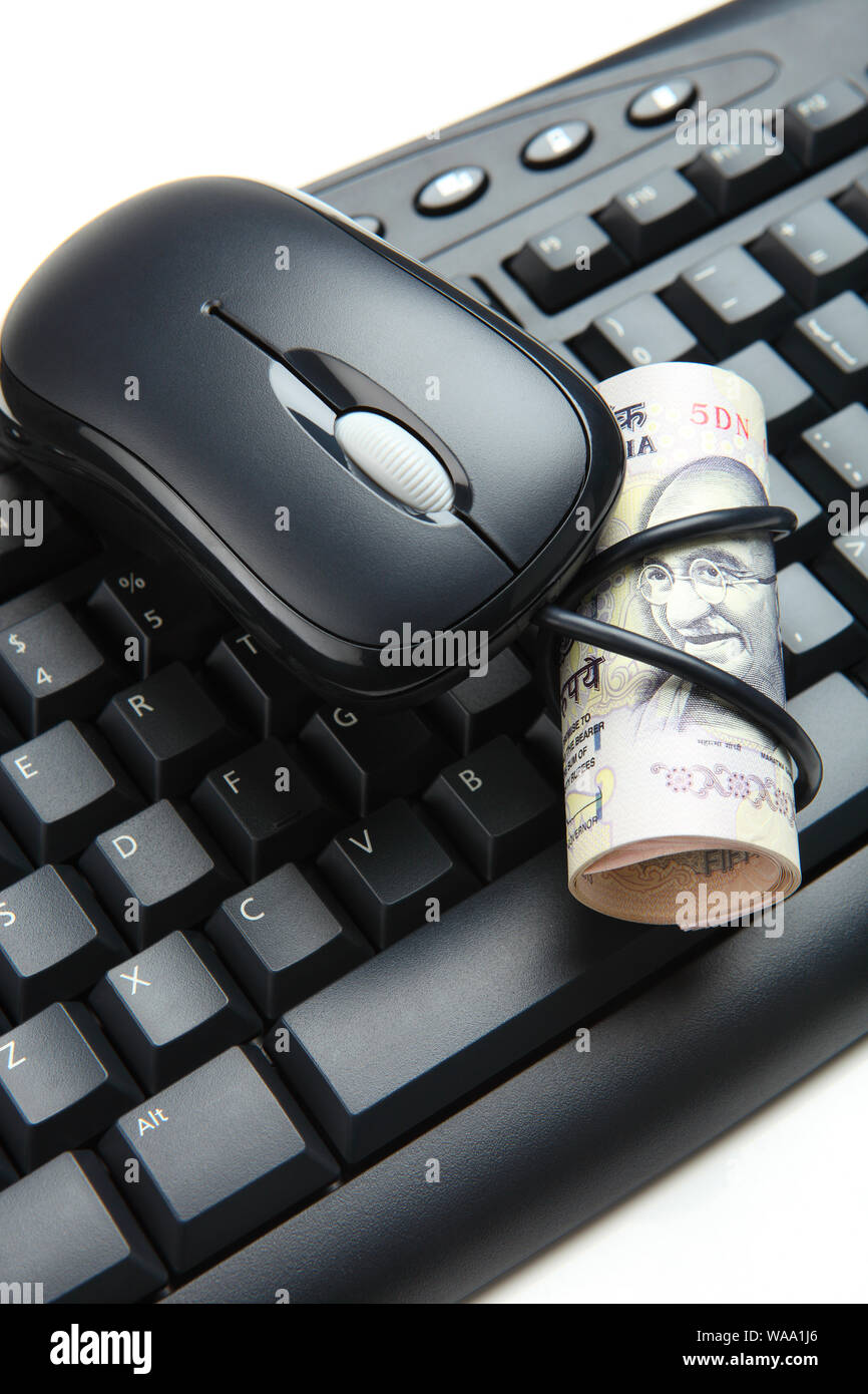 Computer keyboard with mouse and fifty rupee note roll Stock Photo - Alamy