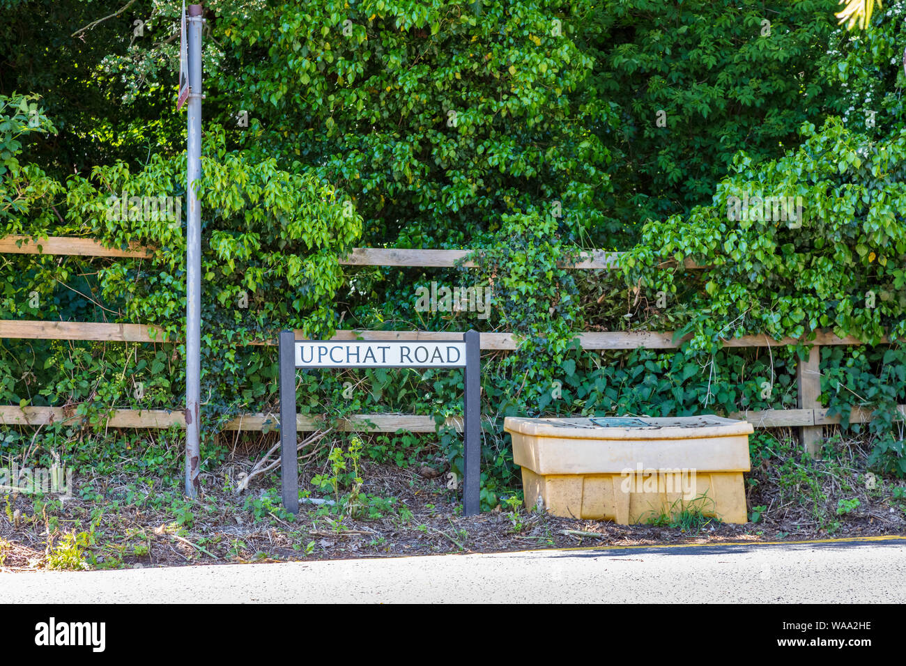 Road sign for Upchat Road in Upnor, Kent. Next to it is a grit and salt ...
