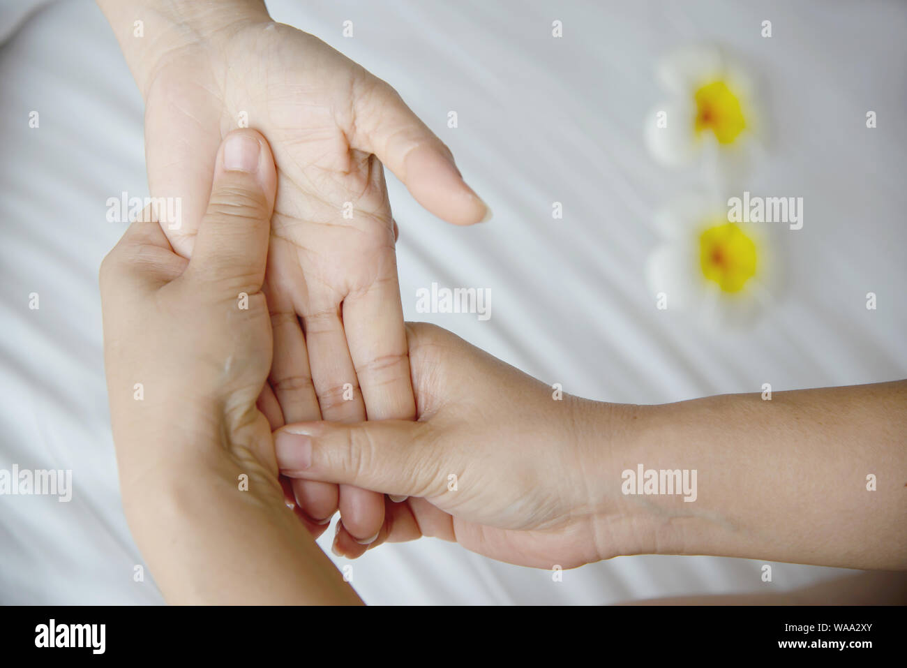 Hand spa massage over clean white bed background - people relax with ...