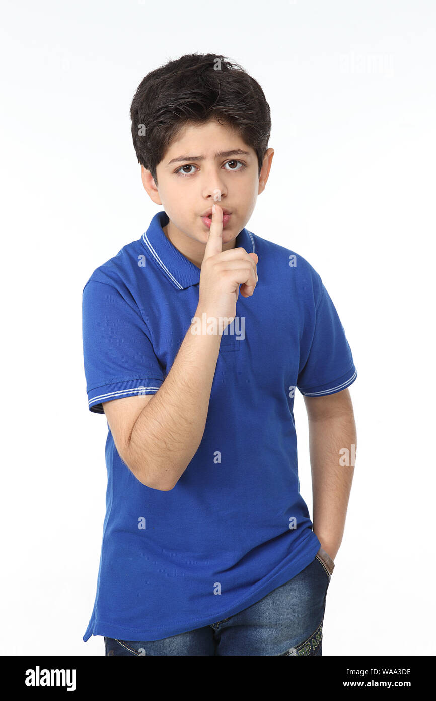 Boy with finger on lips Stock Photo - Alamy