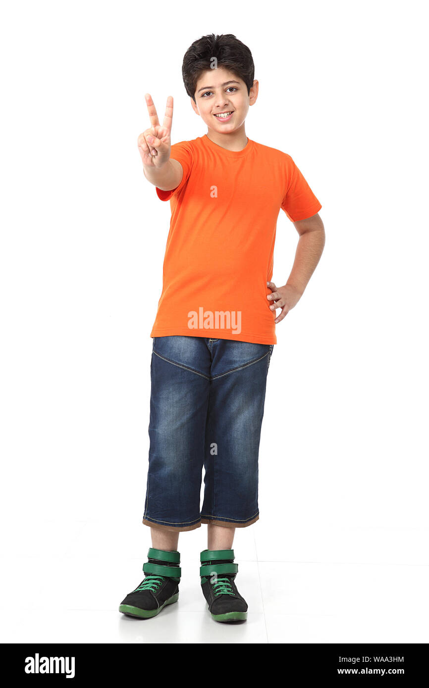 Boy standing and showing v sign Stock Photo - Alamy