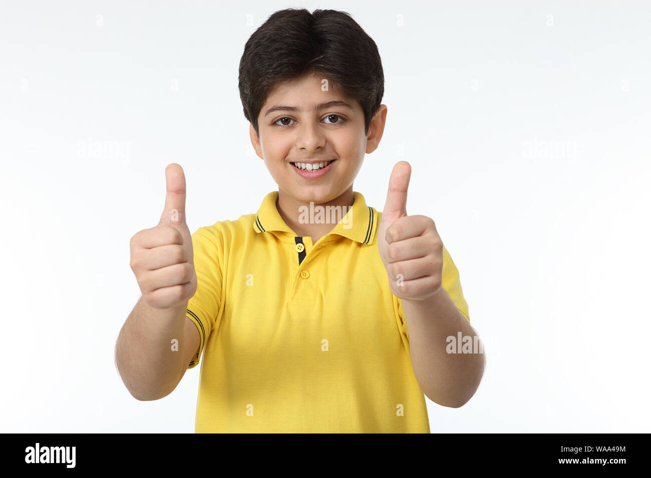 Boy smiling and showing thumbs up sign Stock Photo - Alamy
