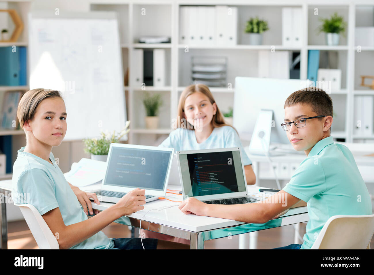Group of clever middle school students looking at you in classroom ...