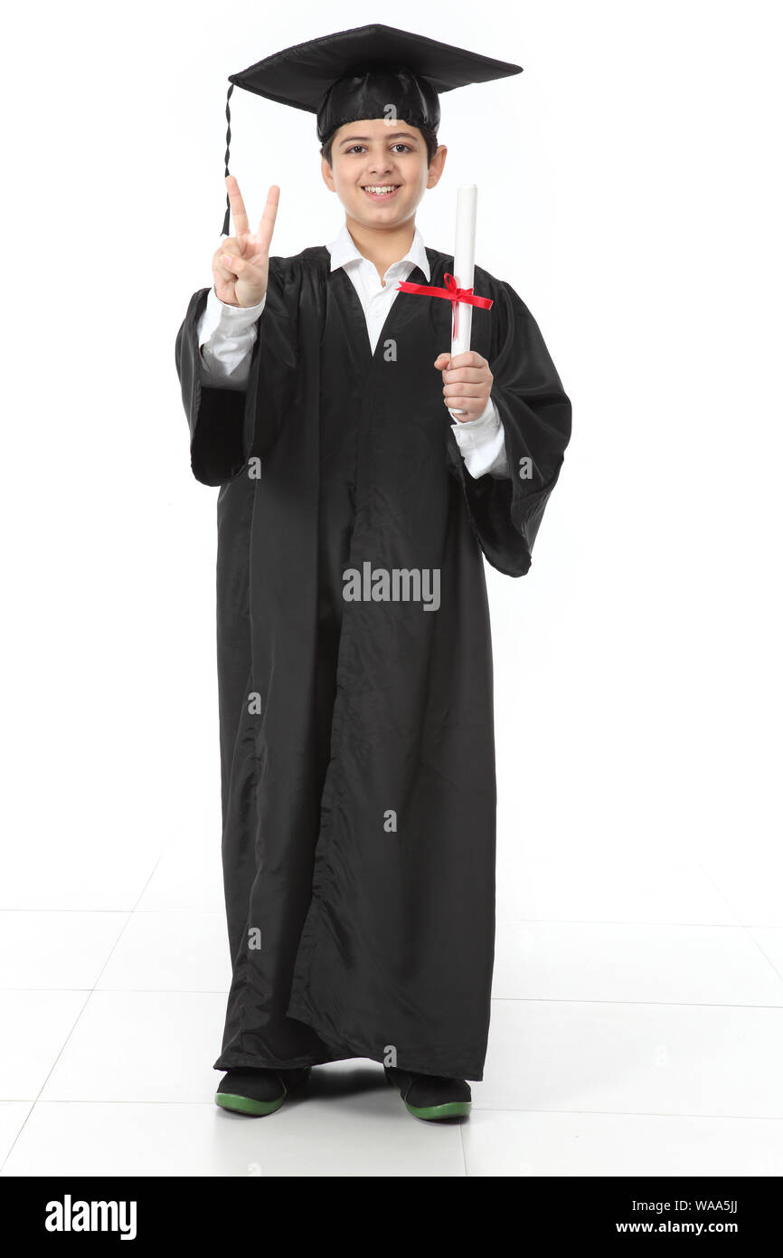 Boy in graduation gown showing a degree Stock Photo - Alamy