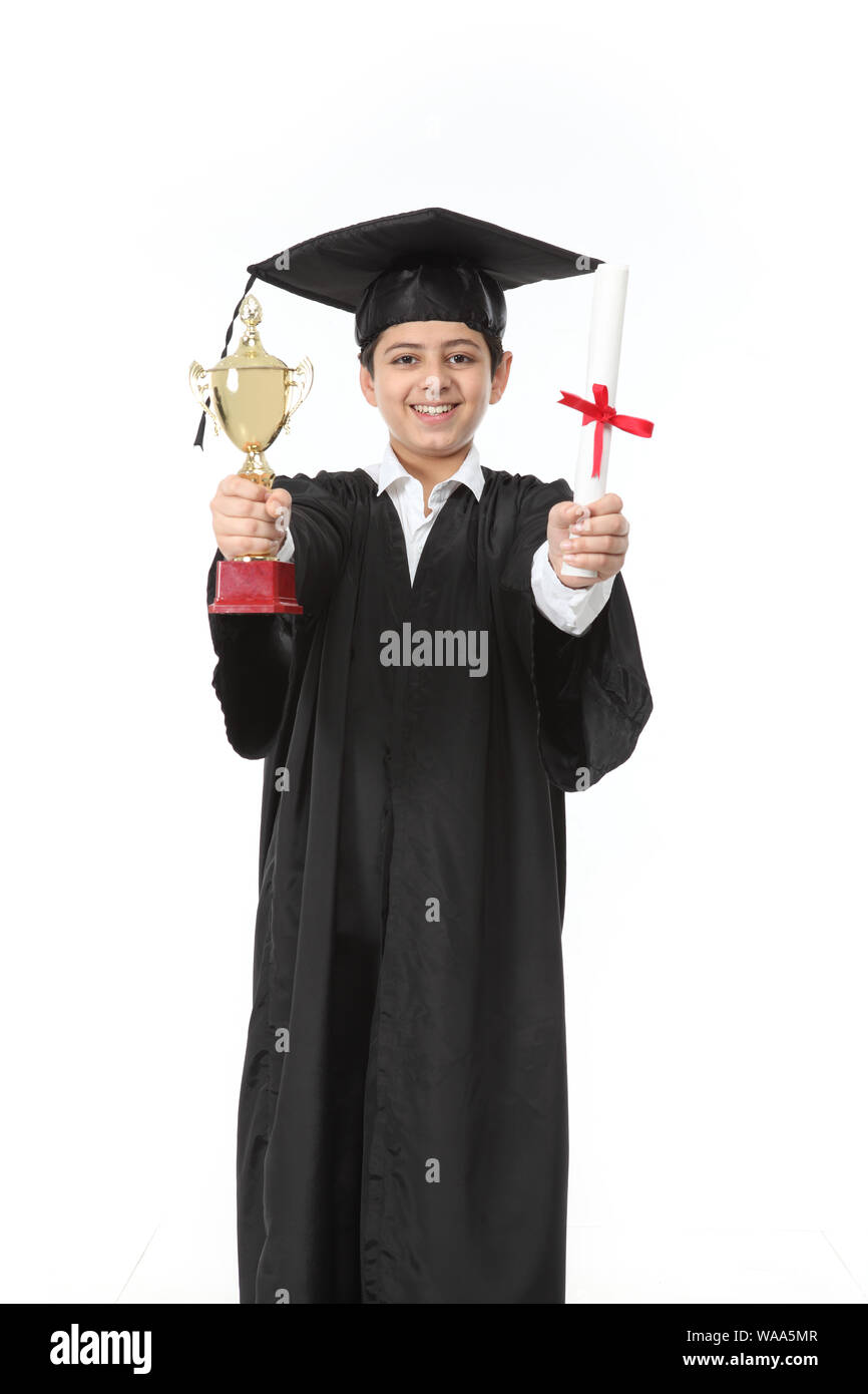 Boy in graduation gown showing a degree with trophy Stock Photo - Alamy
