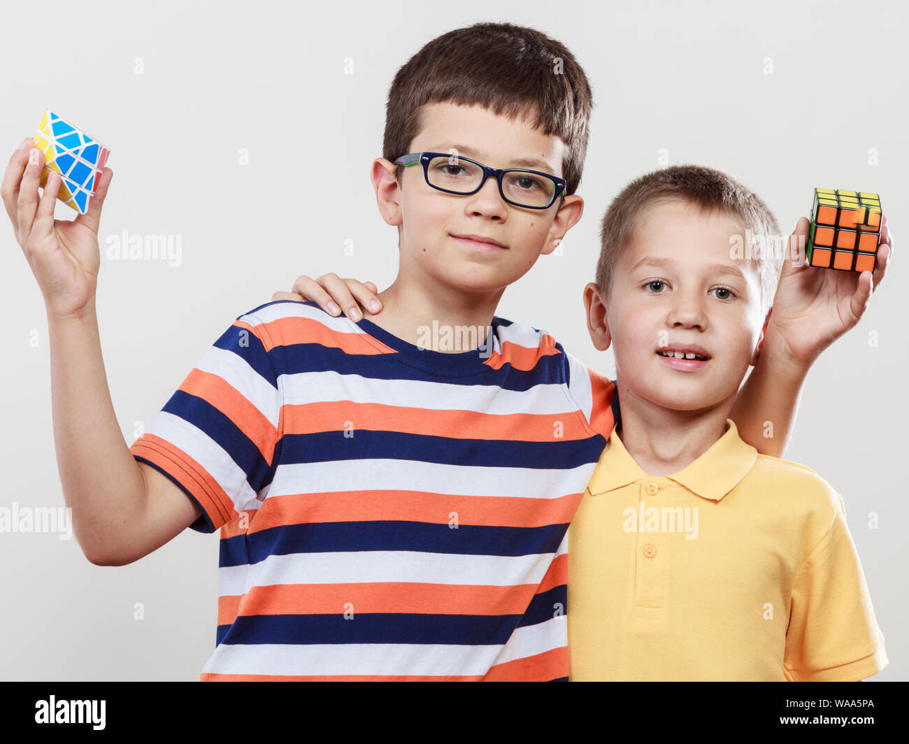 Portrait of smart cute kids little boys with magic rubik cube and ...