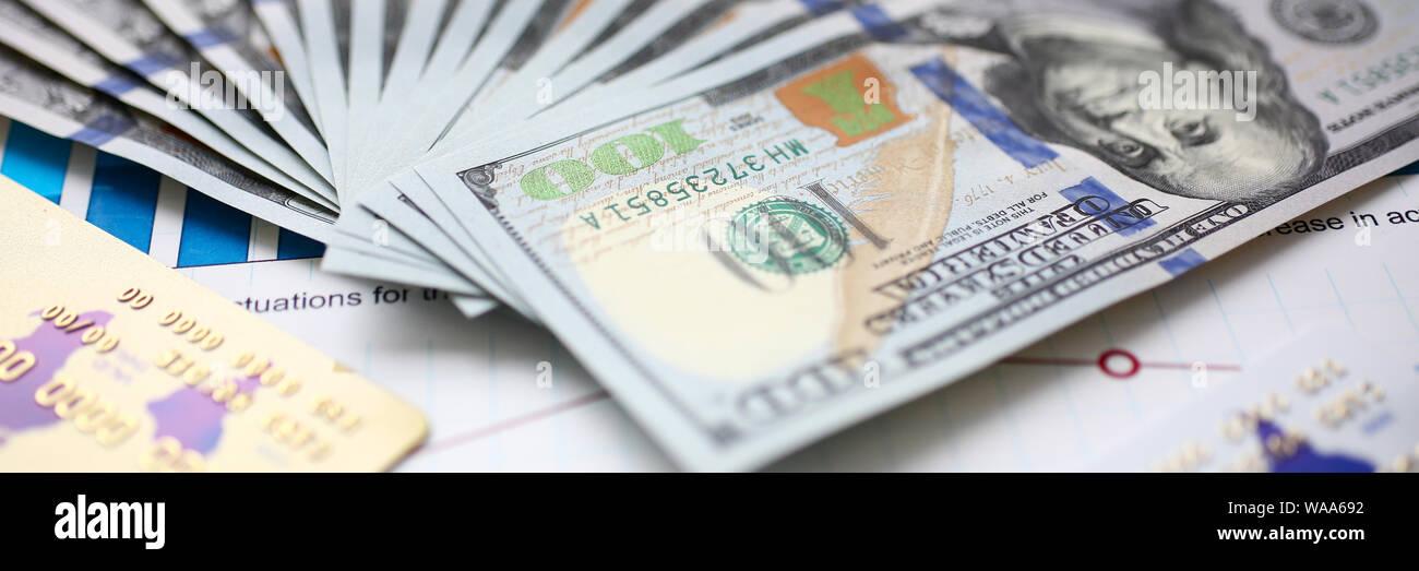 Big amount of US currency on financial statistics graphs Stock Photo ...