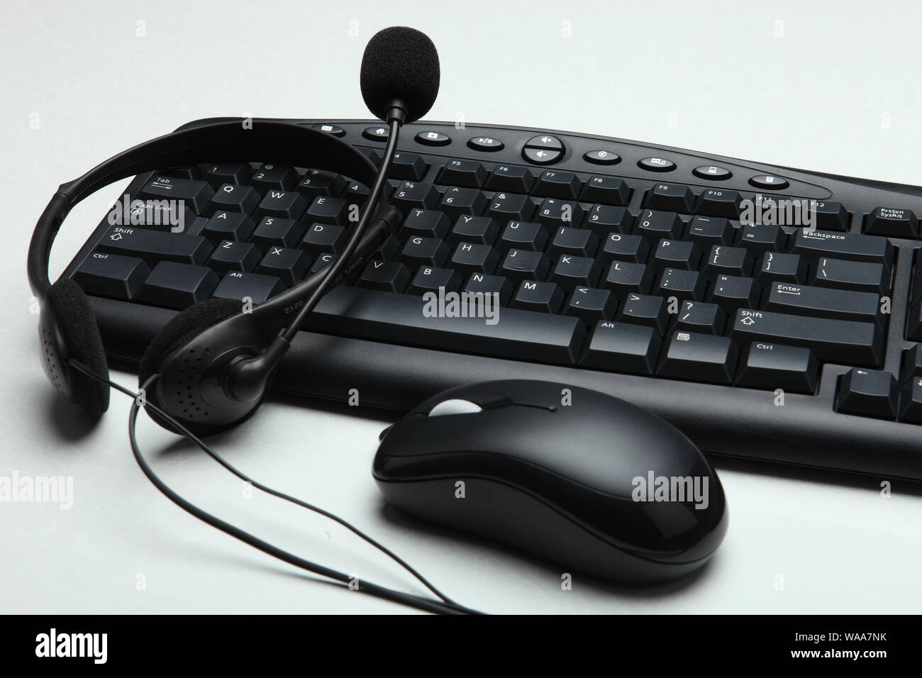 Headset on computer keyboard with mouse Stock Photo - Alamy