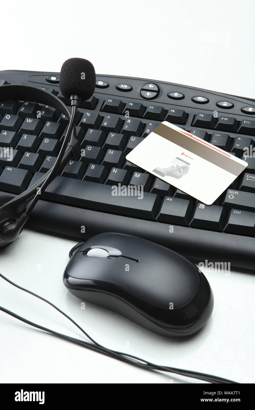 Headset and credit card on computer keyboard with mouse Stock Photo - Alamy
