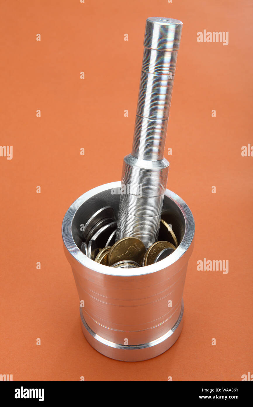 Coin crushing in mortar Stock Photo - Alamy