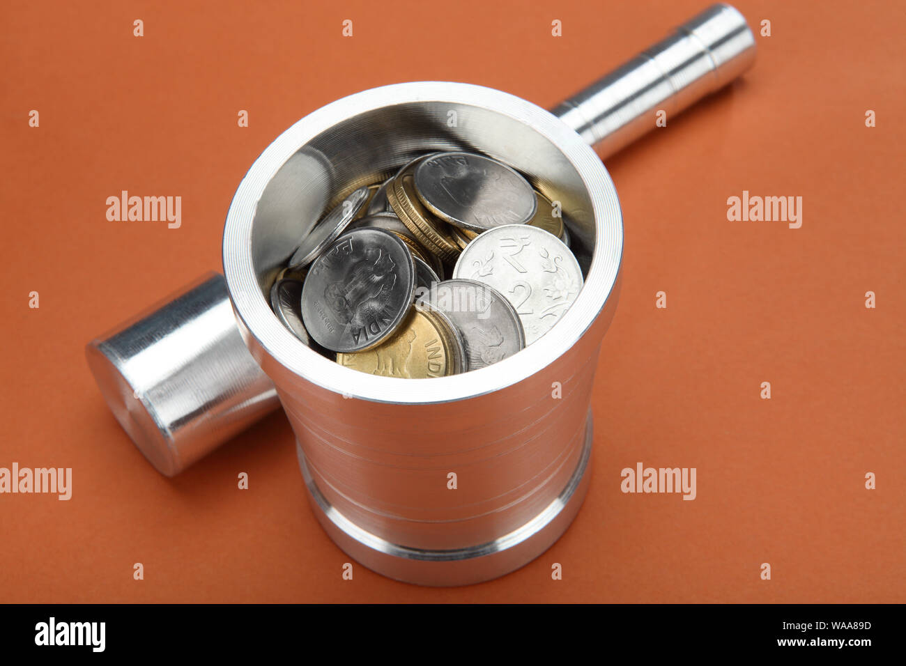 Coin crushing in mortar Stock Photo - Alamy