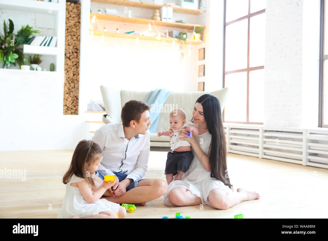 Happy family smiling while playing with colorful blocks at home Stock ...