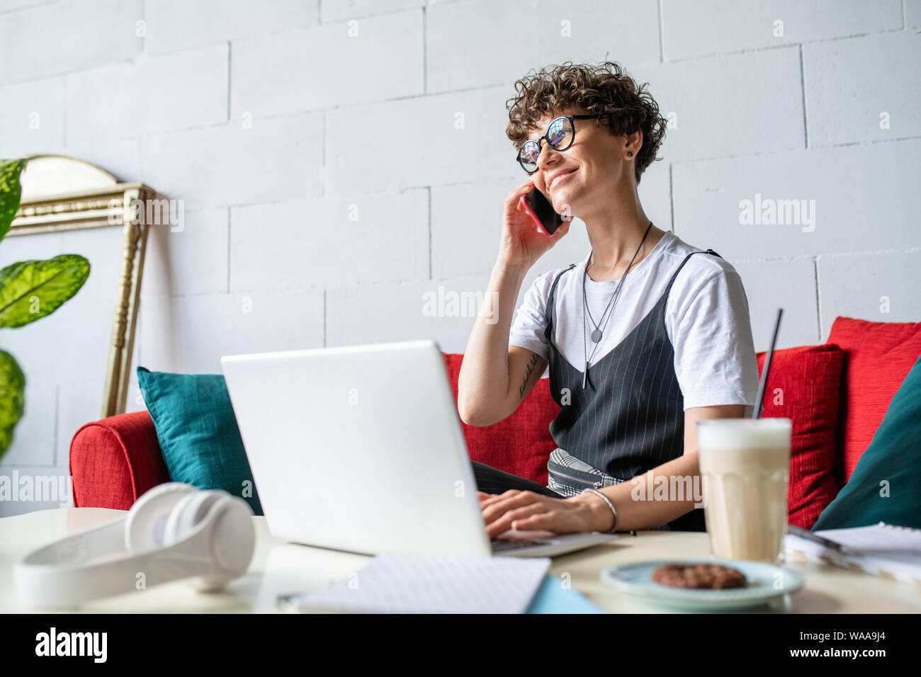 Busy young home office manager consulting clients by smartphone and ...