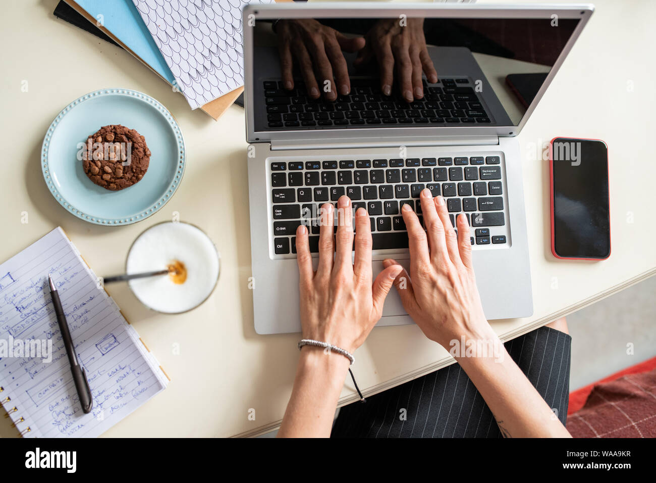 Overview of human hands on laptop keypad during network by desk Stock ...