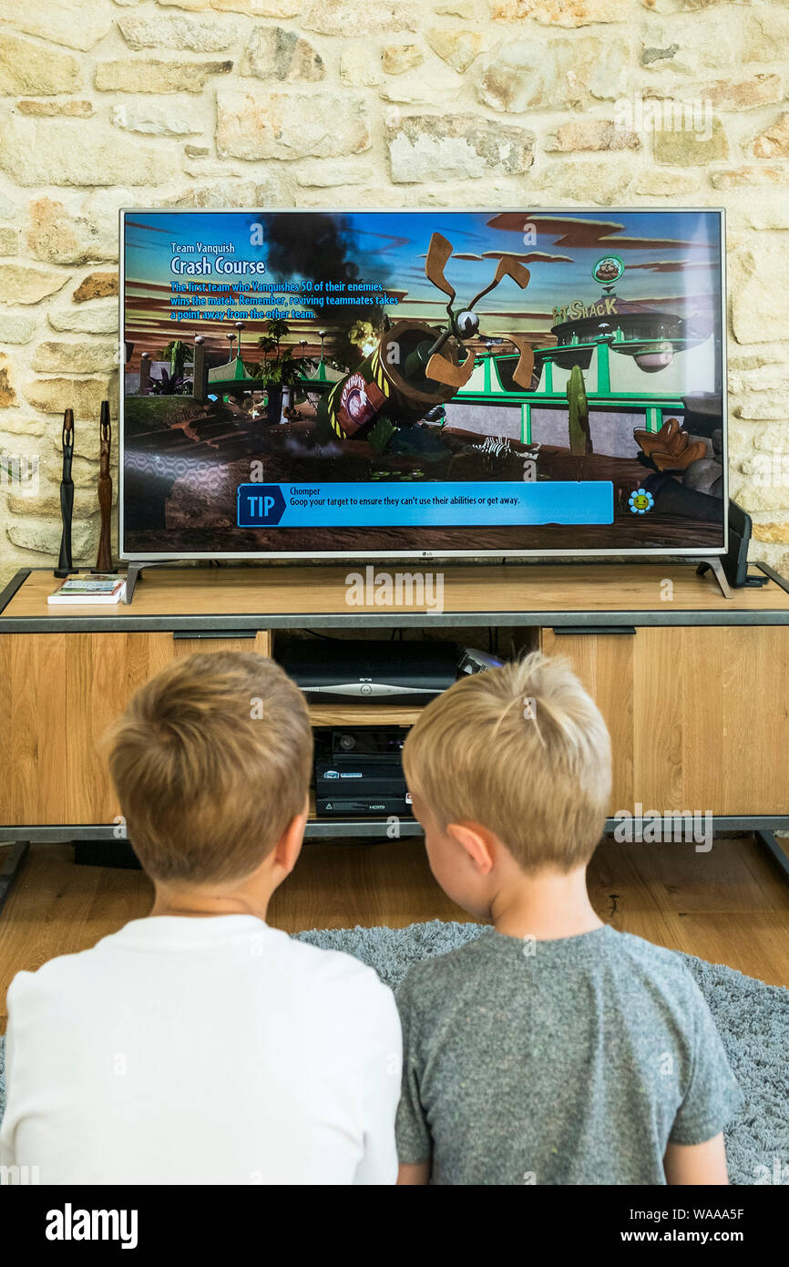 Two young boys playing a video game on a large screen Stock Photo - Alamy