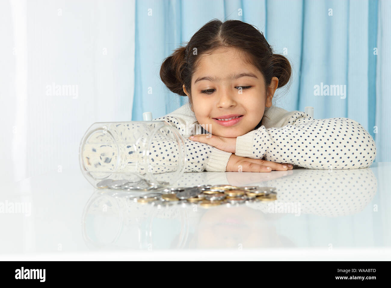 Girl sitting with her savings and smiling Stock Photo - Alamy