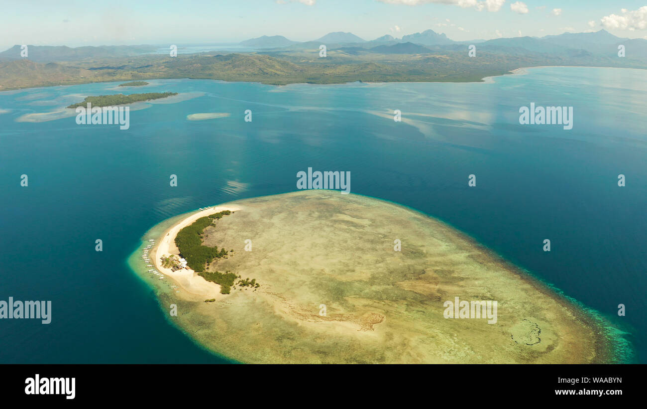 Tropical island and sandy beach with tourists surrounded by coral reef ...