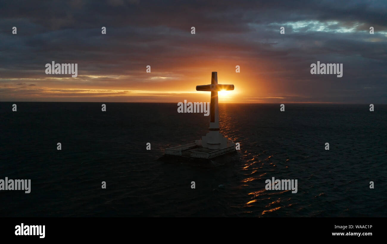 Catholic cross in sunken cemetery in the sea at sunset, aerial view ...