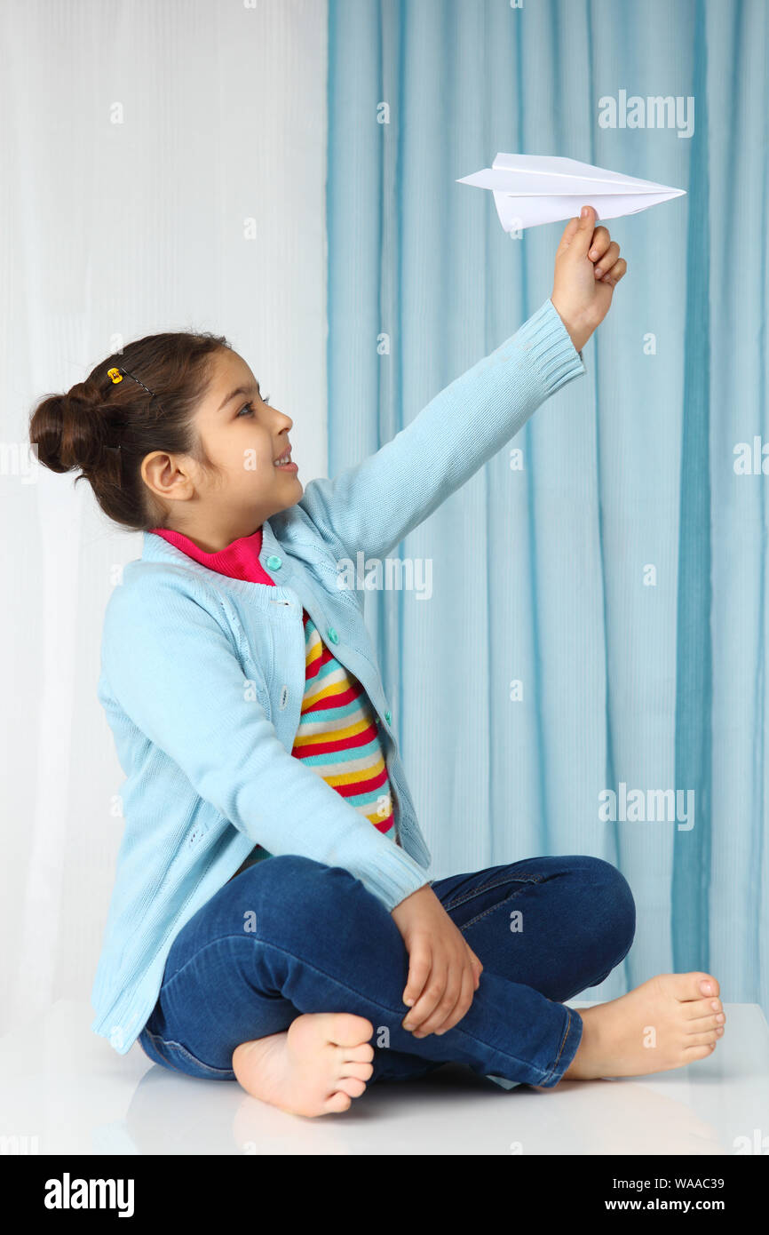 Girl playing with paper airplane Stock Photo - Alamy