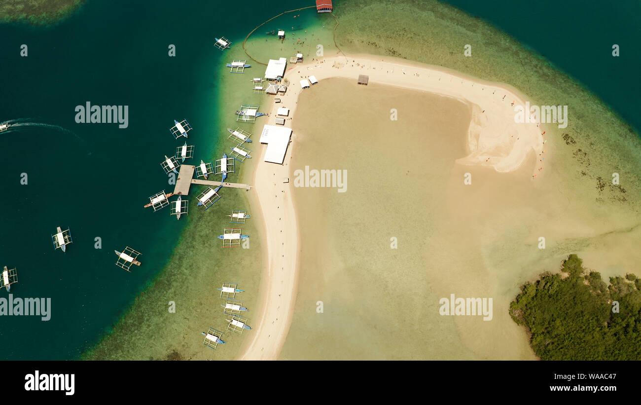 Luli island and sandy beach with tourists, sand bar surrounded by coral ...