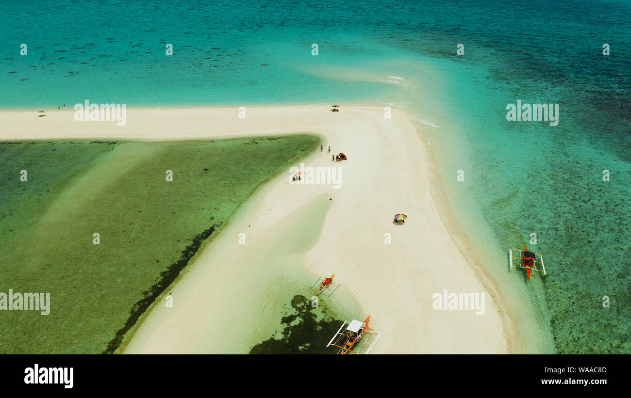 Tropical white island and sandy beach with tourists surrounded by coral ...