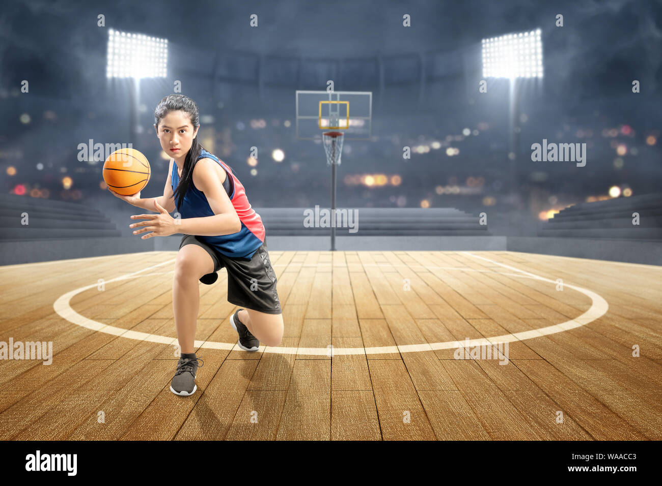 Asian woman basketball player in action with the ball on the indoor ...