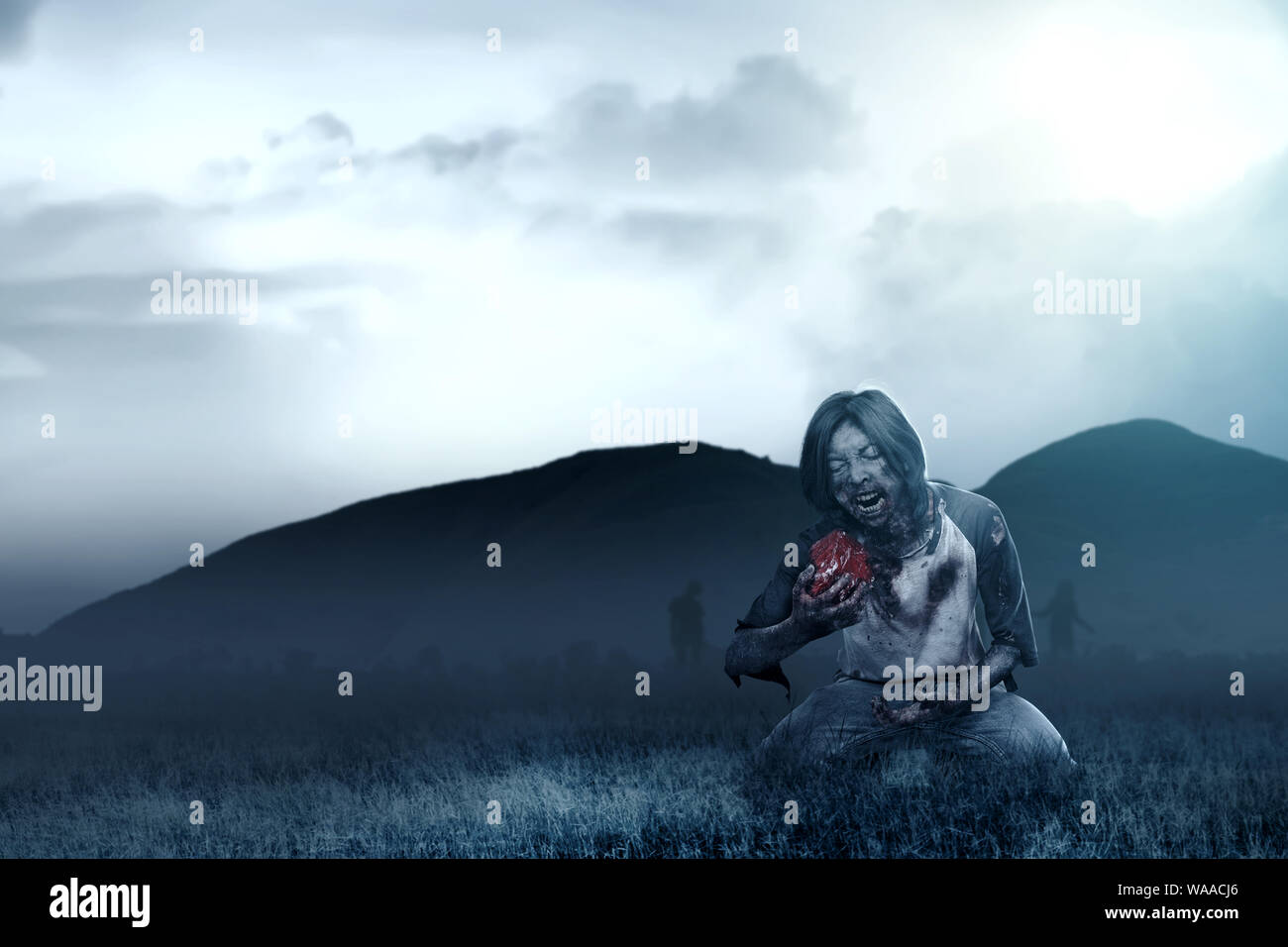 Scary zombies with blood and wound on his body eating the raw meat on ...