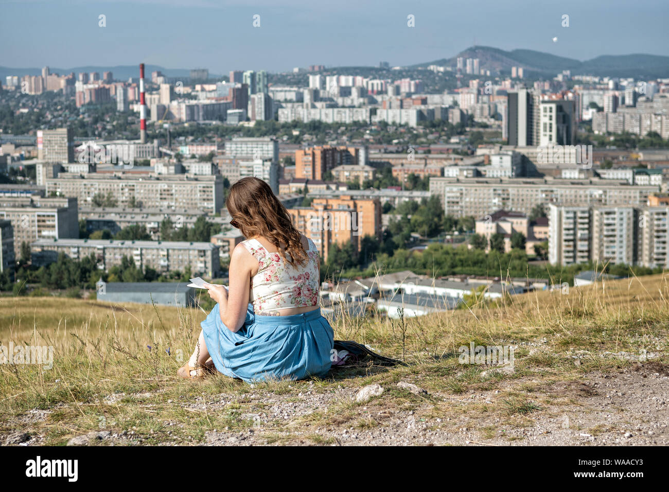 Young woman taking notes in a field above Krasnoyarsk, Siberia, Russia ...