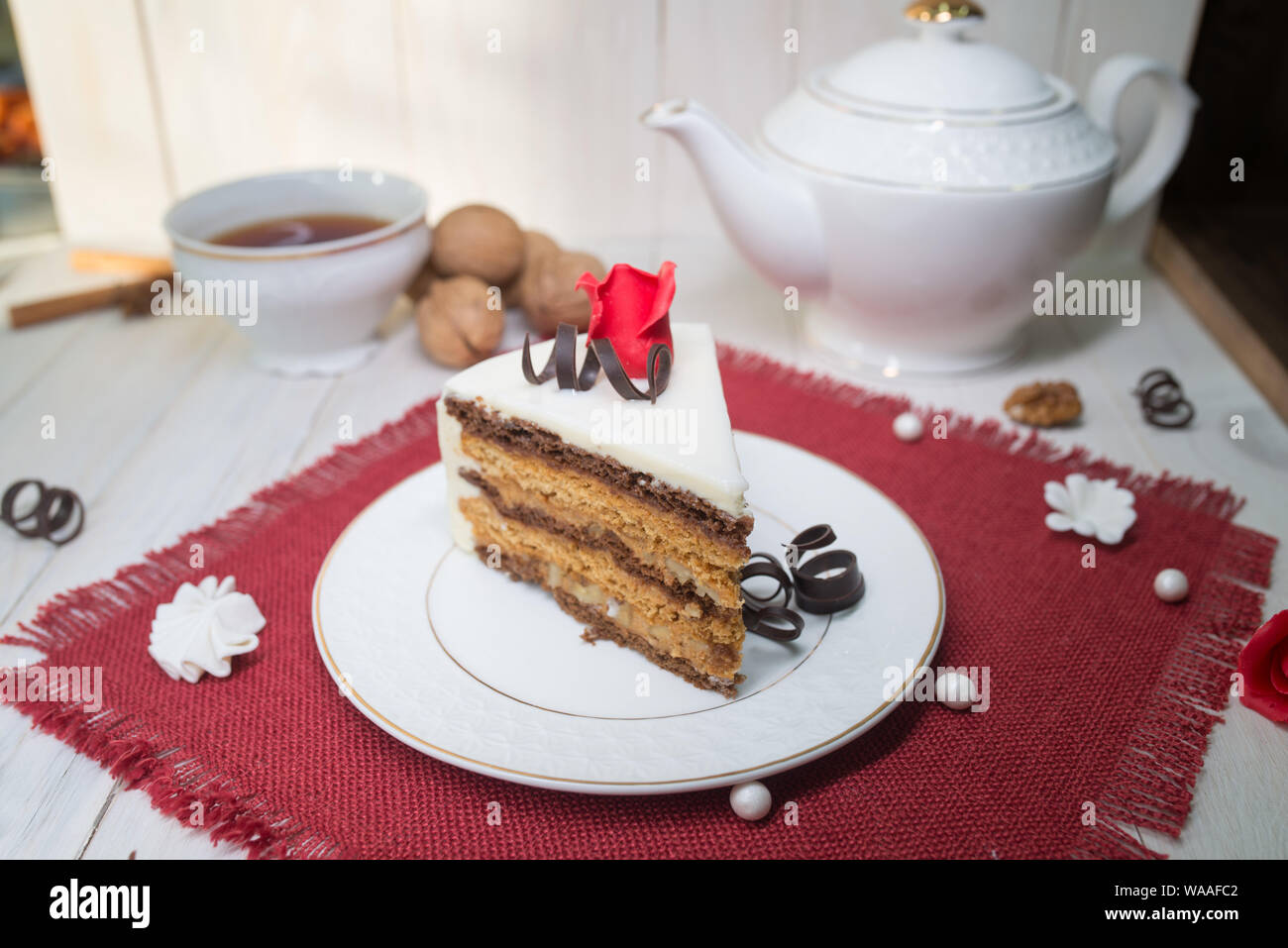 chocolate cake slice with a white cup of tea and a handful Stock Photo ...