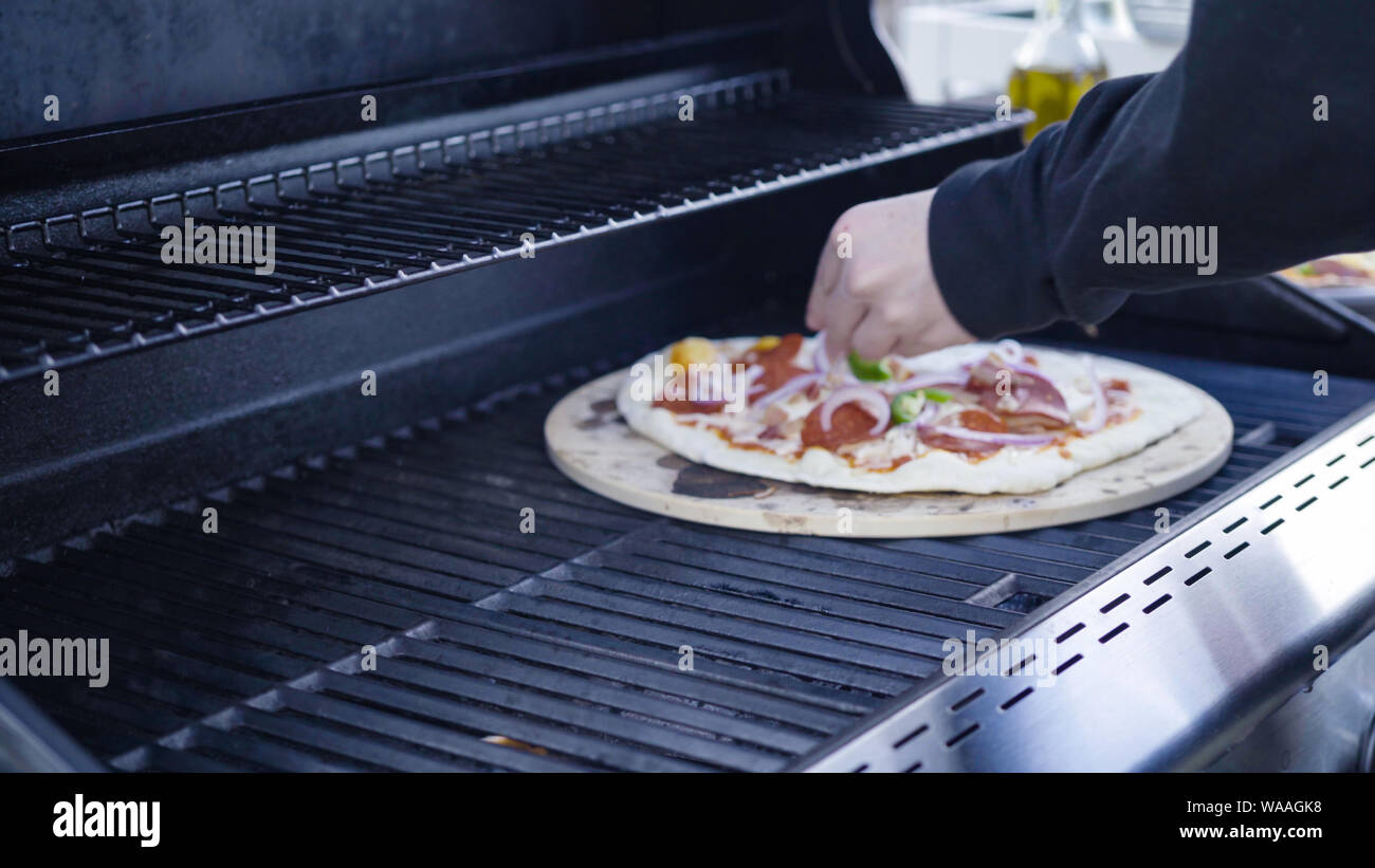 Cooking pizza on outdoor gas grill Stock Photo - Alamy