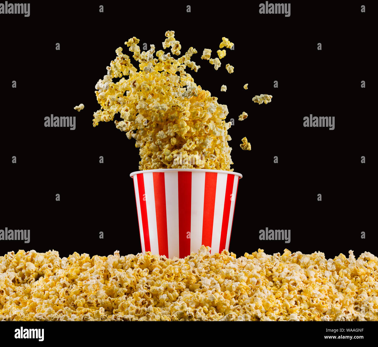 Flying popcorn from striped bucket isolated on black background Stock ...