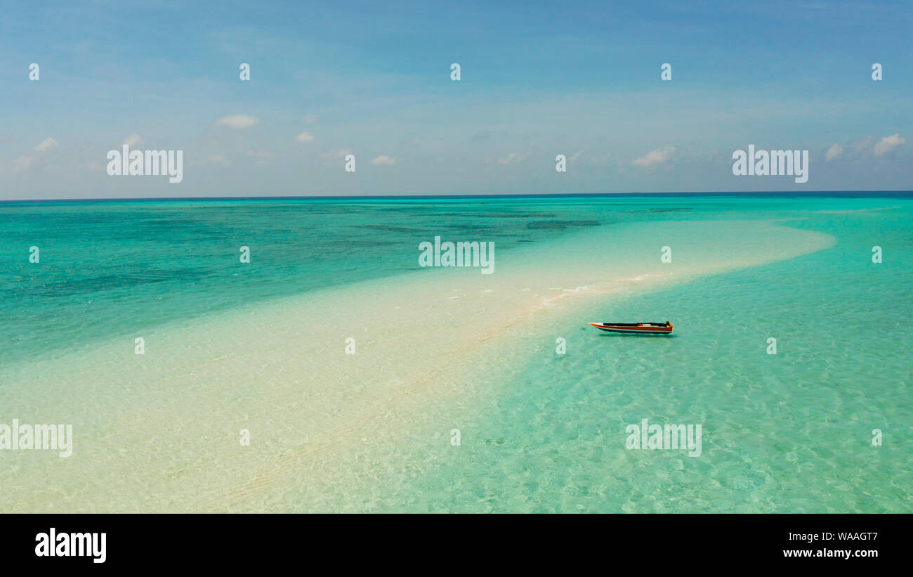 Sandy beach with tourists among turquoise waters and coral reefs ...
