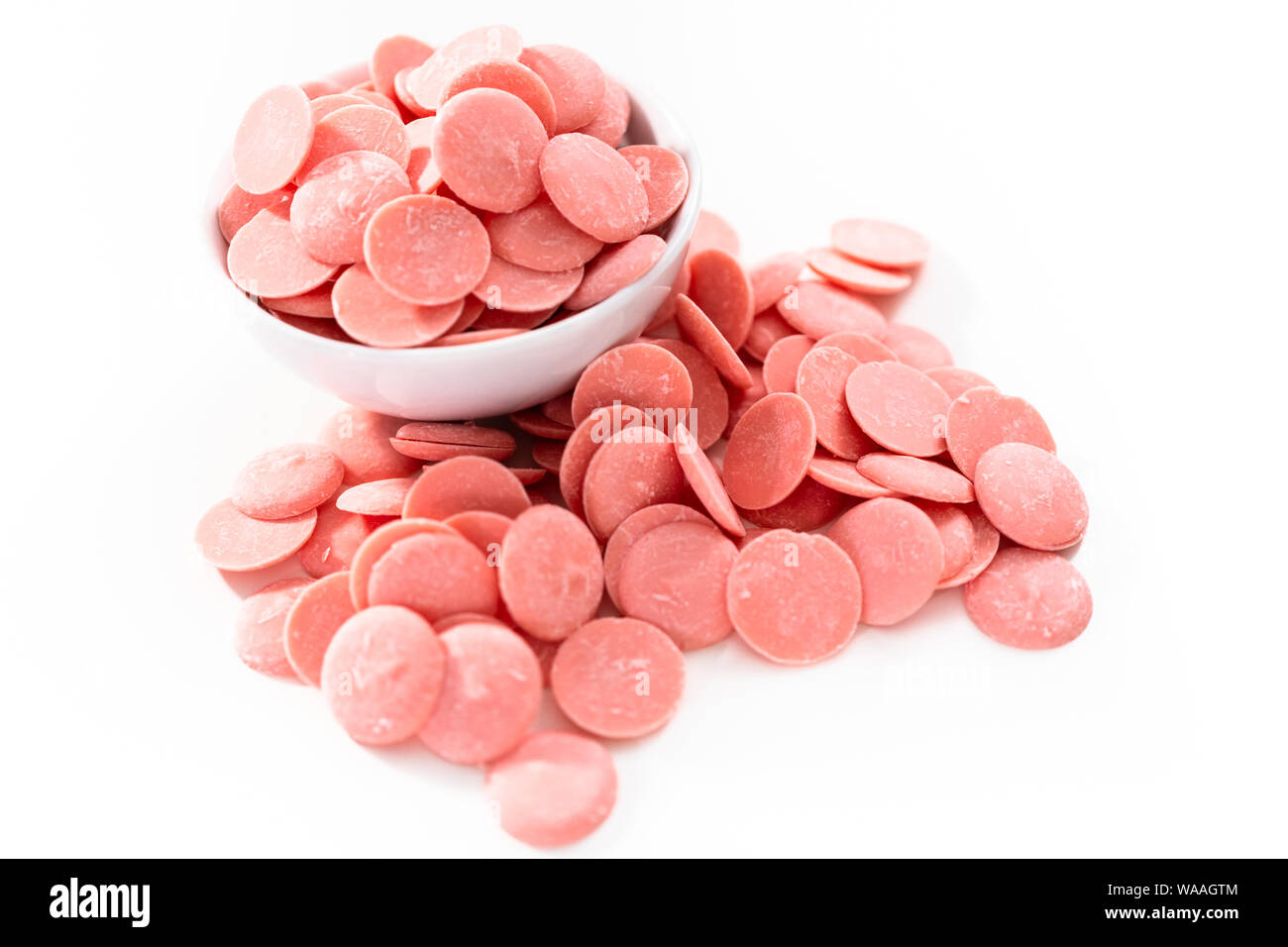 Pink round chocolate chips for melting chocolate shapes on a white ...