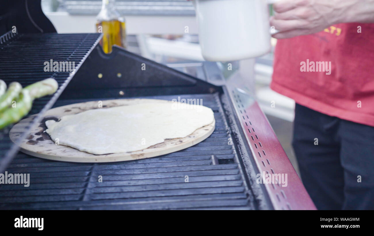 Cooking pizza on outdoor gas grill Stock Photo - Alamy