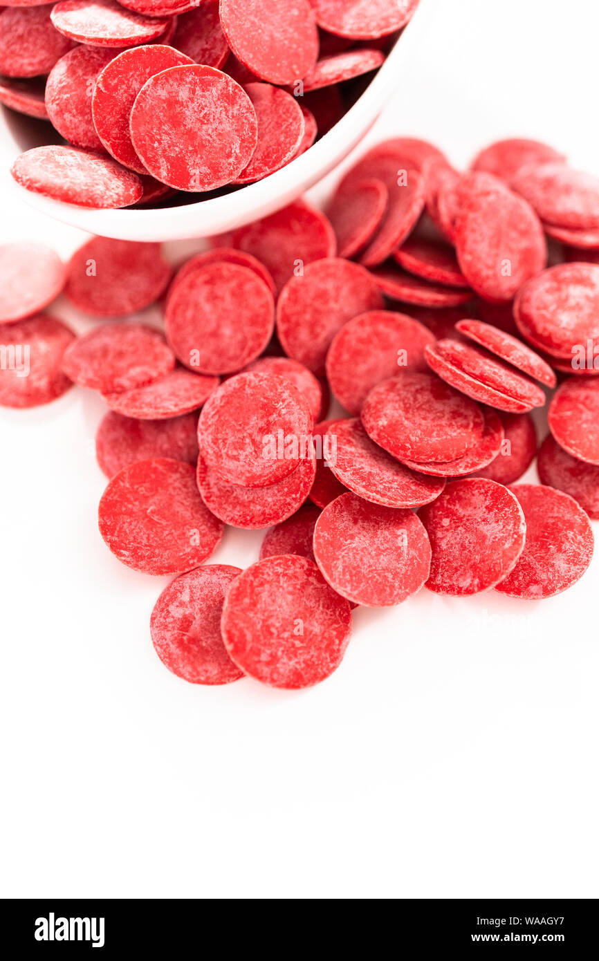 Red round chocolate chips for melting chocolate shapes on a white ...