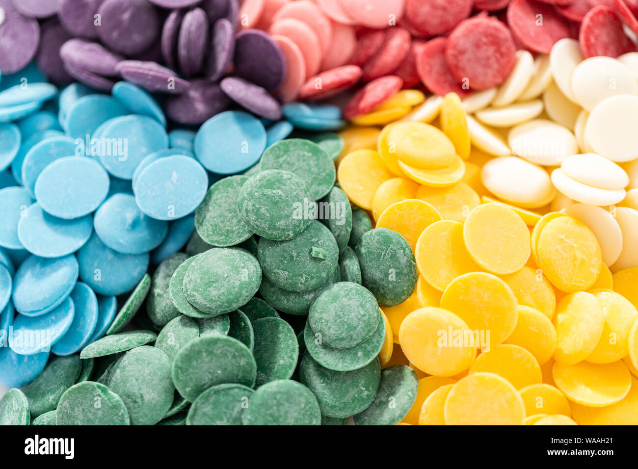 Rainbow colors of round chocolate chips for melting chocolate shapes on ...