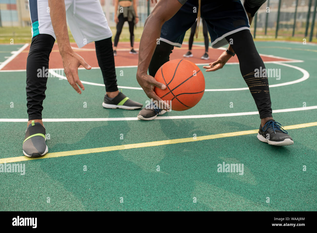 One of young intercultural basketball players taking away the ball ...