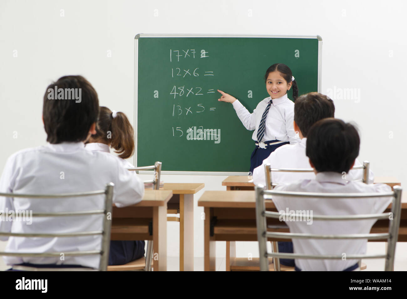 Schoolgirl teaching his classmates in a classroom Stock Photo - Alamy