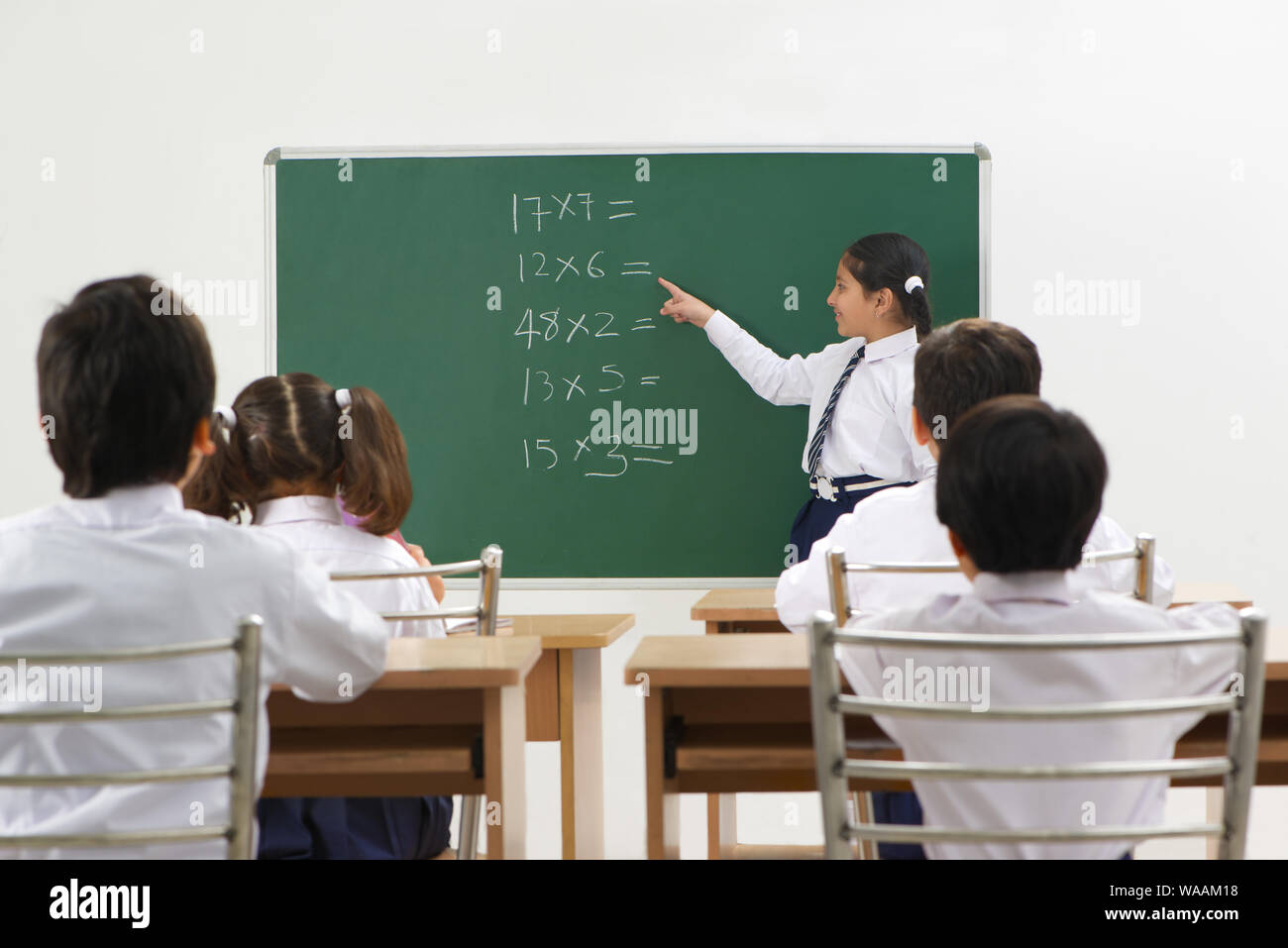 Schoolgirl teaching his classmates in a classroom Stock Photo - Alamy