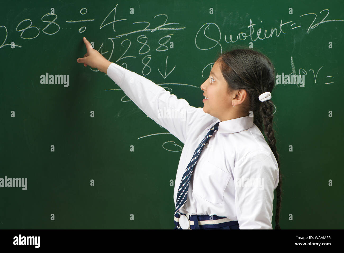 Schoolgirl pointing on blackboard Stock Photo - Alamy