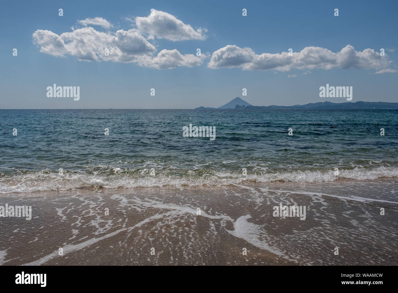 Standing on the beach looking across Kagoshima Bay on a beautiful blue ...