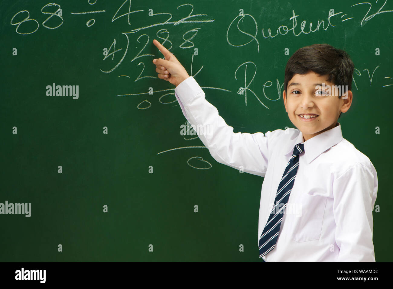 Schoolboy pointing on blackboard Stock Photo - Alamy