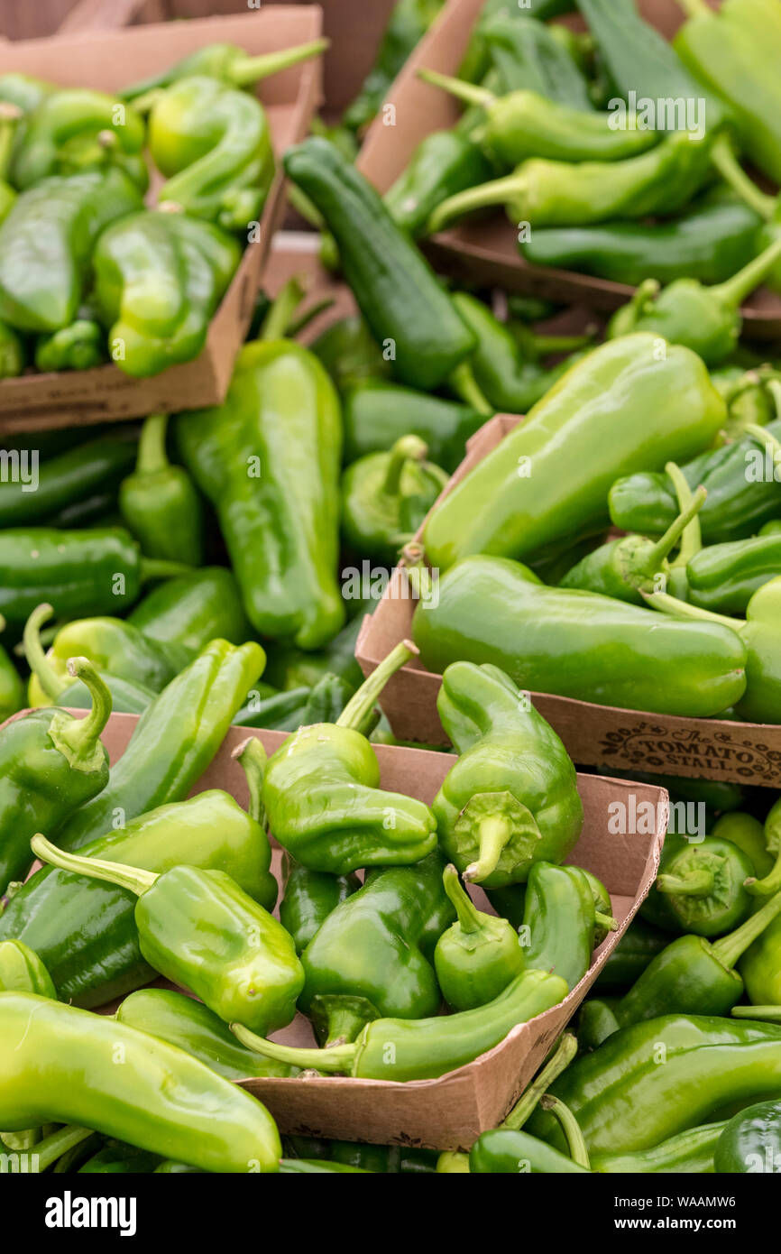 green chillies or chilli peppers on display at a fruit and vegetables ...