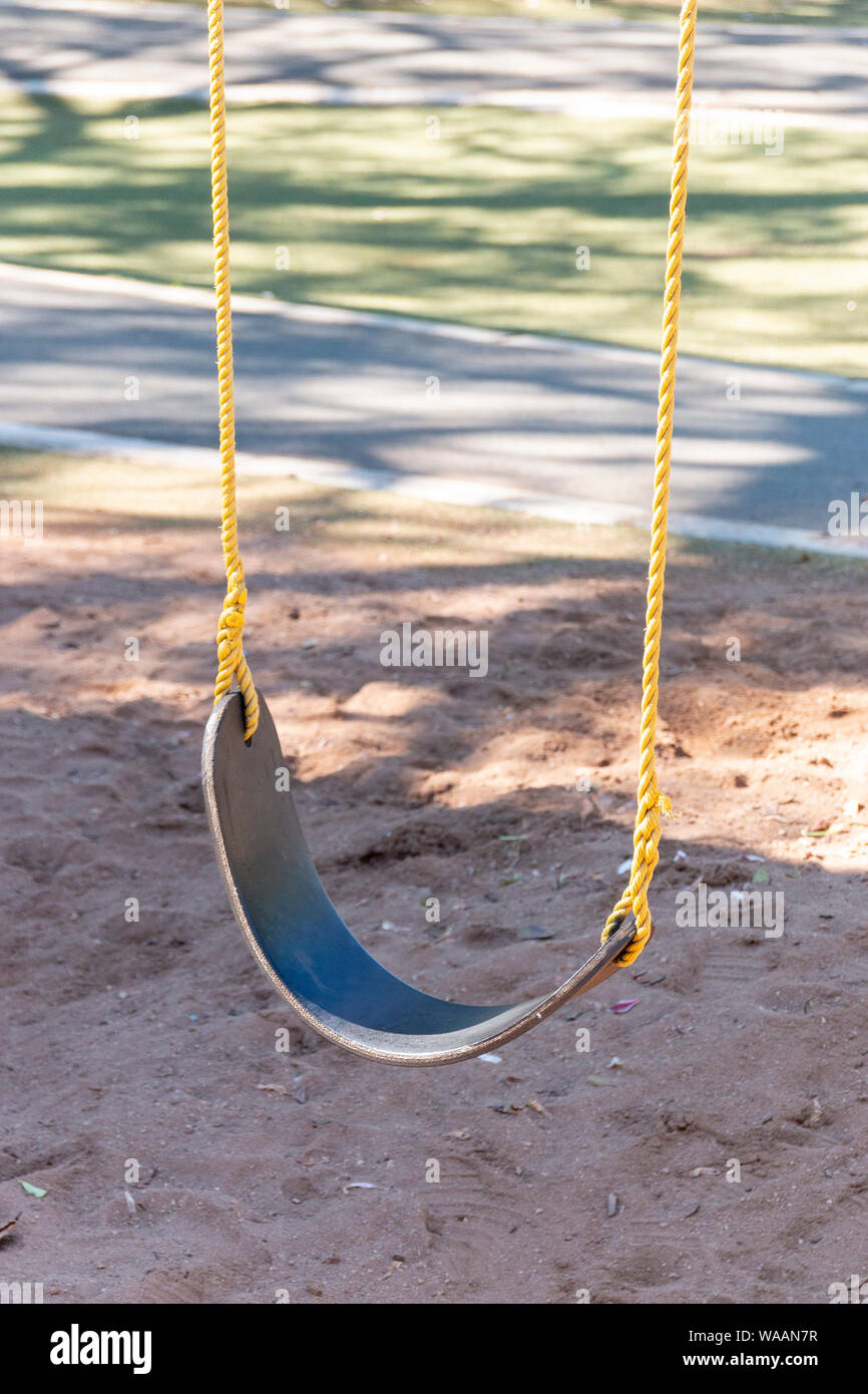 A close up view of the bottom half of childerns rubber swing in a sand ...
